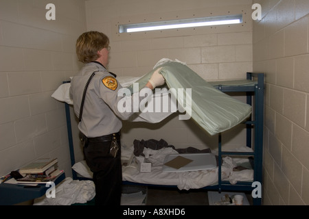 Prison guard, correctional officer, searching the cell of an inmate in ...