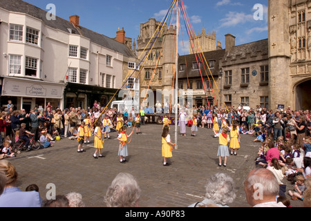 Children dance round the ancient maypole on the village green of Wellow ...