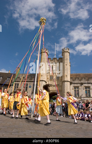 Children dance round the ancient maypole on the village green of Wellow ...
