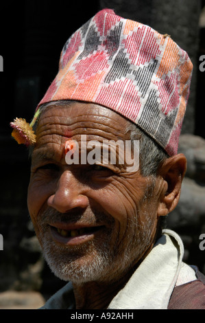Portrait Newari man with traditional hat and flower on his forehead ...
