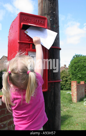 Young girl at post box, reaching up to post letter Stock Photo - Alamy