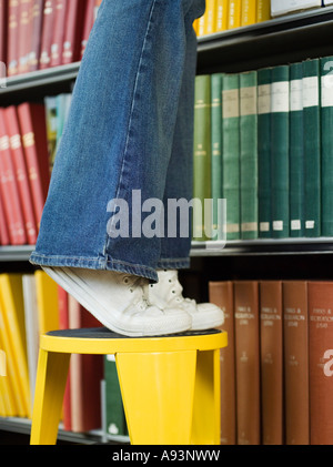 A young woman standing on a stool facing her tall boyfriend Stock Photo ...