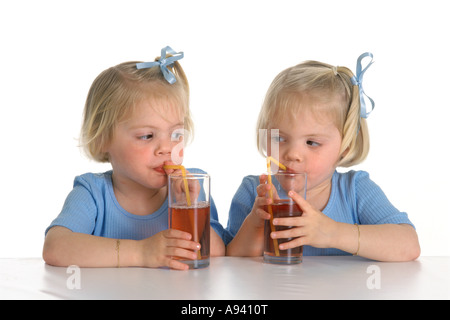 Blond twin girls drinking lemonade together Stock Photo - Alamy