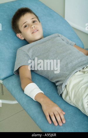 Boy lying on examination table, doctor feeling chest Stock Photo - Alamy