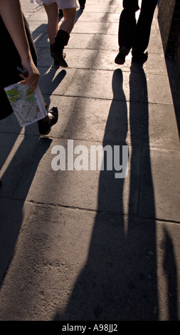 Passing footsteps of pedestrian silhouetted against the late afternoon ...