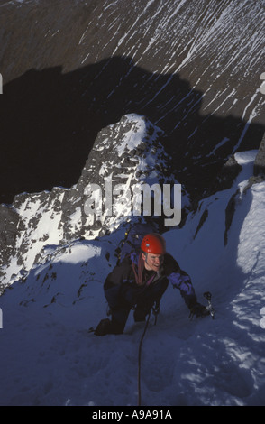 Climber approaching the summit of Ben Nevis via Tower Ridge in winter ...