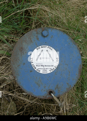 Bore hole or borehole inspection cover in a field Stock Photo - Alamy