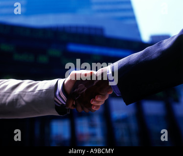 OFFICE WORKERS HANDSHAKE BY STOCK MARKET TICKER DISPLAY Stock Photo - Alamy