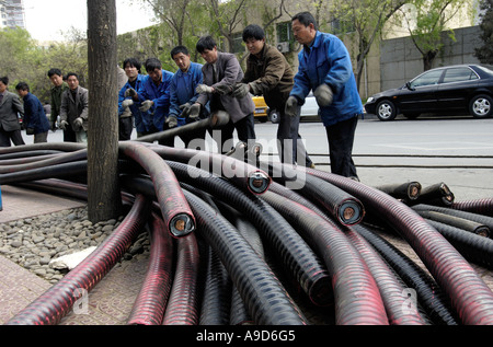 Chinese workers replace electric cables on a street in Beijing China 19 ...