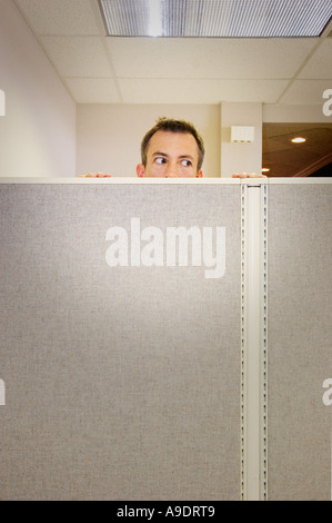 Office worker peering over cubicle wall Stock Photo: 72510779 - Alamy