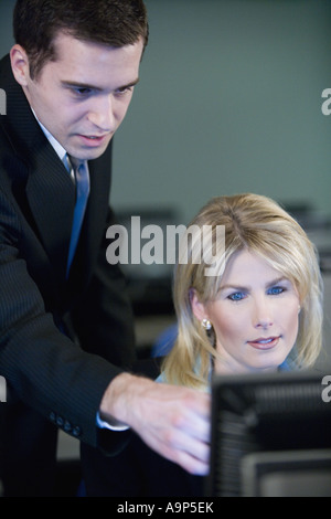 Two business people looking at monitor sitting in office Stock Photo ...