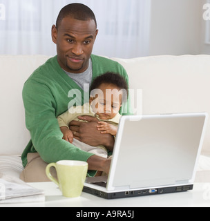 toddler african american child typing on laptop near cheerful mother ...