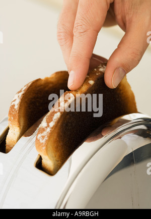 Taking toast out of a toaster Stock Photo - Alamy