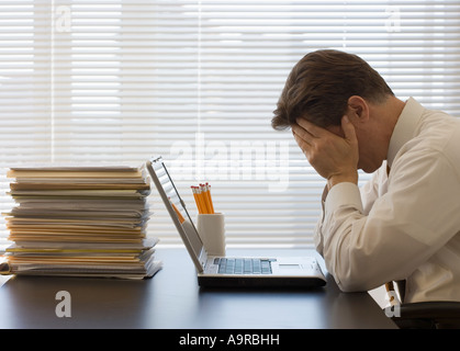Businessman with head in hands Stock Photo - Alamy