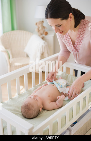 Mid adult woman changing baby son's nappy in garden Stock Photo ...