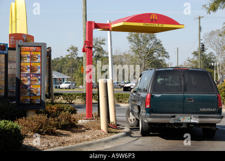 Cars use a drive through window to order and pick up fast food at a ...
