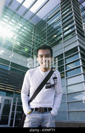 University student standing outside campus building Stock Photo - Alamy