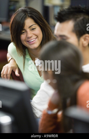 Students conversing while using computers in the library Stock Photo ...
