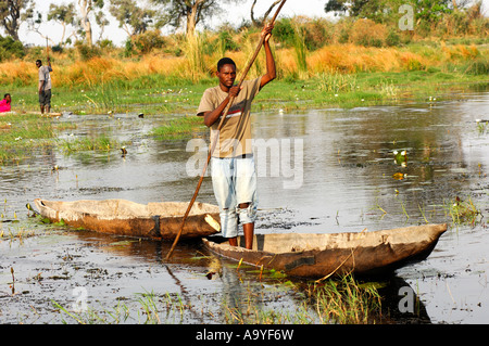 Botswana people Bayei mokoro poler at sunset in the Okovango Delta ...