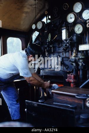 Steam Train driver putting coal in fire At Sherringham in Norfolk Uk ...