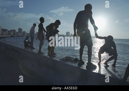 Cuban kids playing and diving in the sea from the Malecon in Havana ...