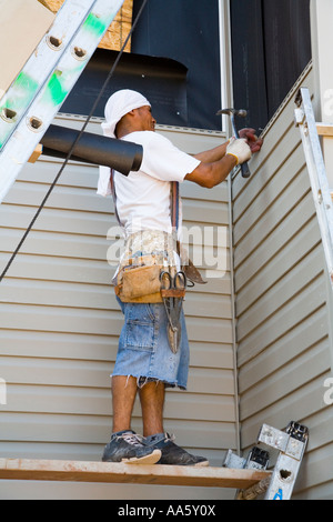 Immigrant Workers Installing vinyl Siding Stock Photo - Alamy