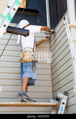Immigrant Workers Installing vinyl Siding Stock Photo - Alamy