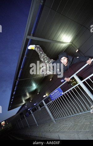 A parkour freerunning athlete vaulting over a wall on a rooftop with ...