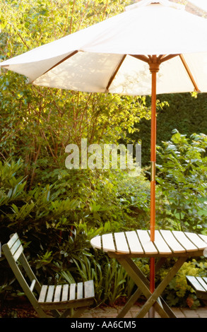 Small garden with wooden chairs and small table on artificial lawn ...
