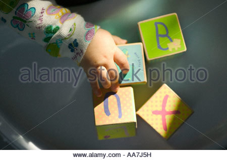 Toddler picking up small objects using the pincer grip Stock Photo ...
