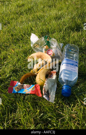 Discarded picnic litter and plastic packaging rubbish dumped on tarmac ...
