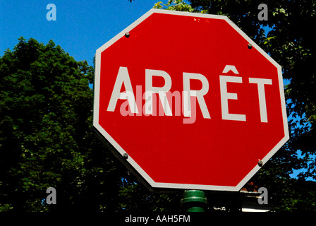 French language traffic stop sign sticking out of Thuja occidentalis ...