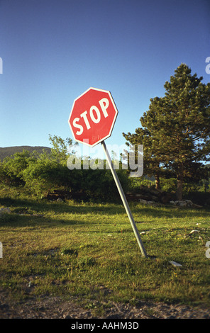 Leaning stop sign in countryside Stock Photo - Alamy