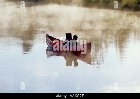 Man in canoe using laptop computer Stock Photo - Alamy