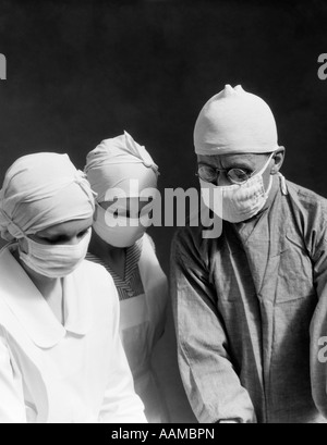 1930s SURGERY TEAM WEARING WHITE GOWNS CAPS AND MASKS IN HOSPITAL ...