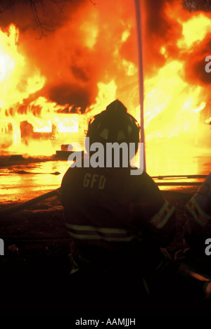 A firefighting team putting water on a fire in an industrial building ...