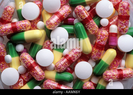 multicolored pills and capsules on a green background Stock Photo - Alamy