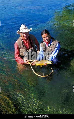 IDAHO Guide and woman fisherman releasing Brown Trout Siver Creek Sun ...