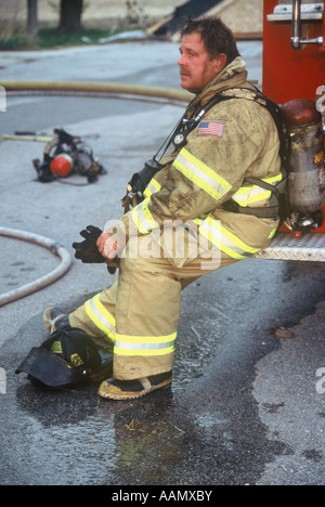 Sad, exhausted firefighter in uniform tiredly rubbing forehead in ...