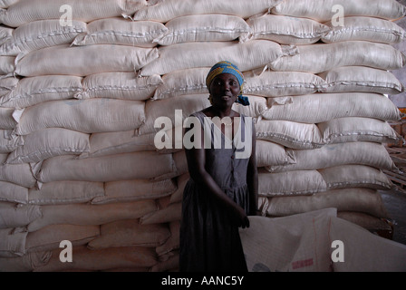 A woman stands amid sacks of basic foodstuffs at a storage warehouse of ...
