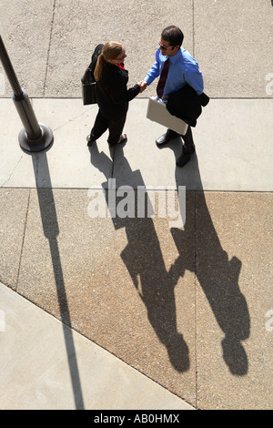 Businesspeople shaking hands with shadows on ground Stock Photo - Alamy