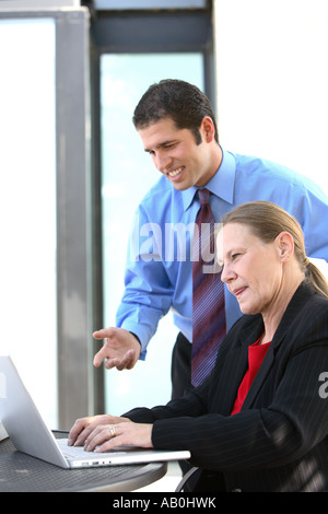Young business man working together with her colleague on laptop in ...