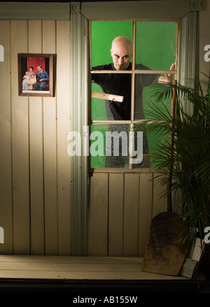 Sinister character in window, illuminated by harsh lighting Stock Photo ...