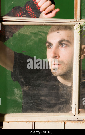 Sinister character peering through a broken window Stock Photo - Alamy