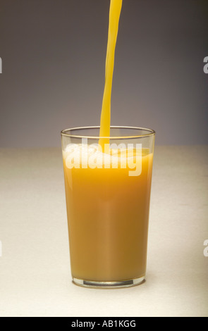 Orange Juice being poured into Glass against White Background Stock ...
