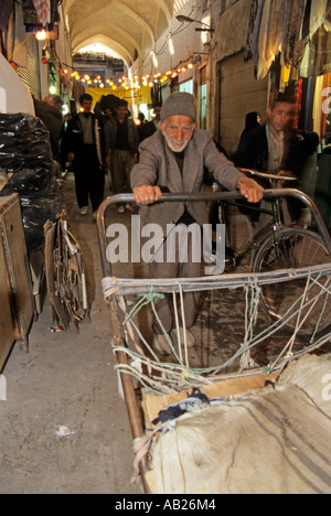 Middle eastern man pushing a shopping cart with falling food assortment ...