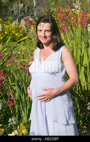 Pregnant 40 year old mother to be puts hand over belly and baby during ...