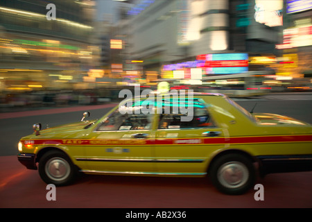 A Japanese taxi (yellow cab) in a street with other traffic in Shinjuku ...