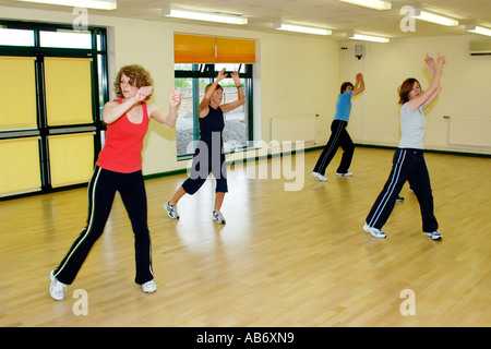 Females doing hip wiggle and clapping exercises in a workout class ...