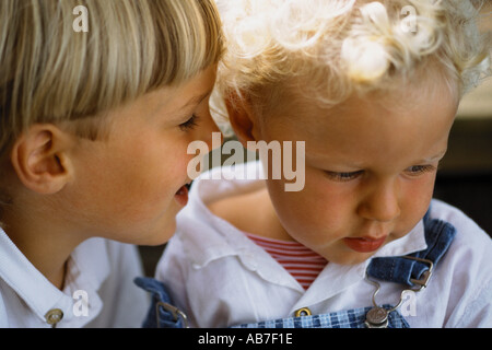 Sister whispering to her brother Stock Photo - Alamy